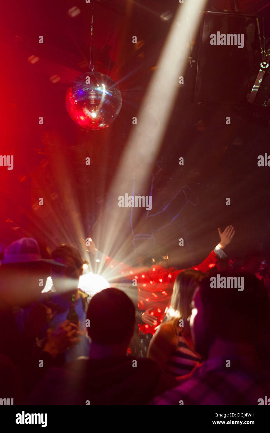 Nightclub scene with people dancing, disco ball, lighting equipment ...