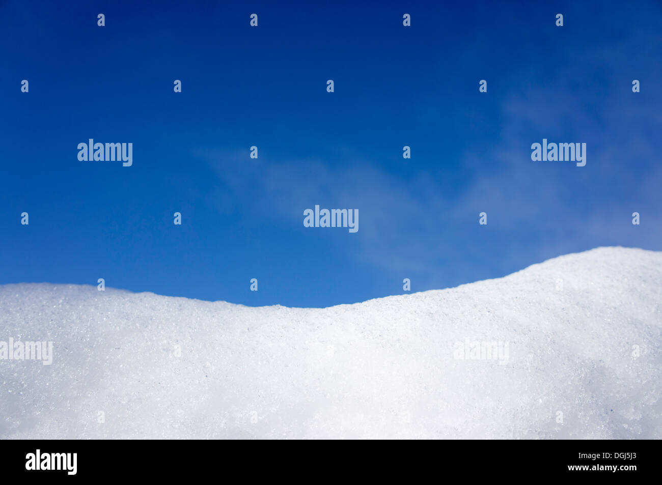 White snow isolated against blue skies with shallow depth of field ...