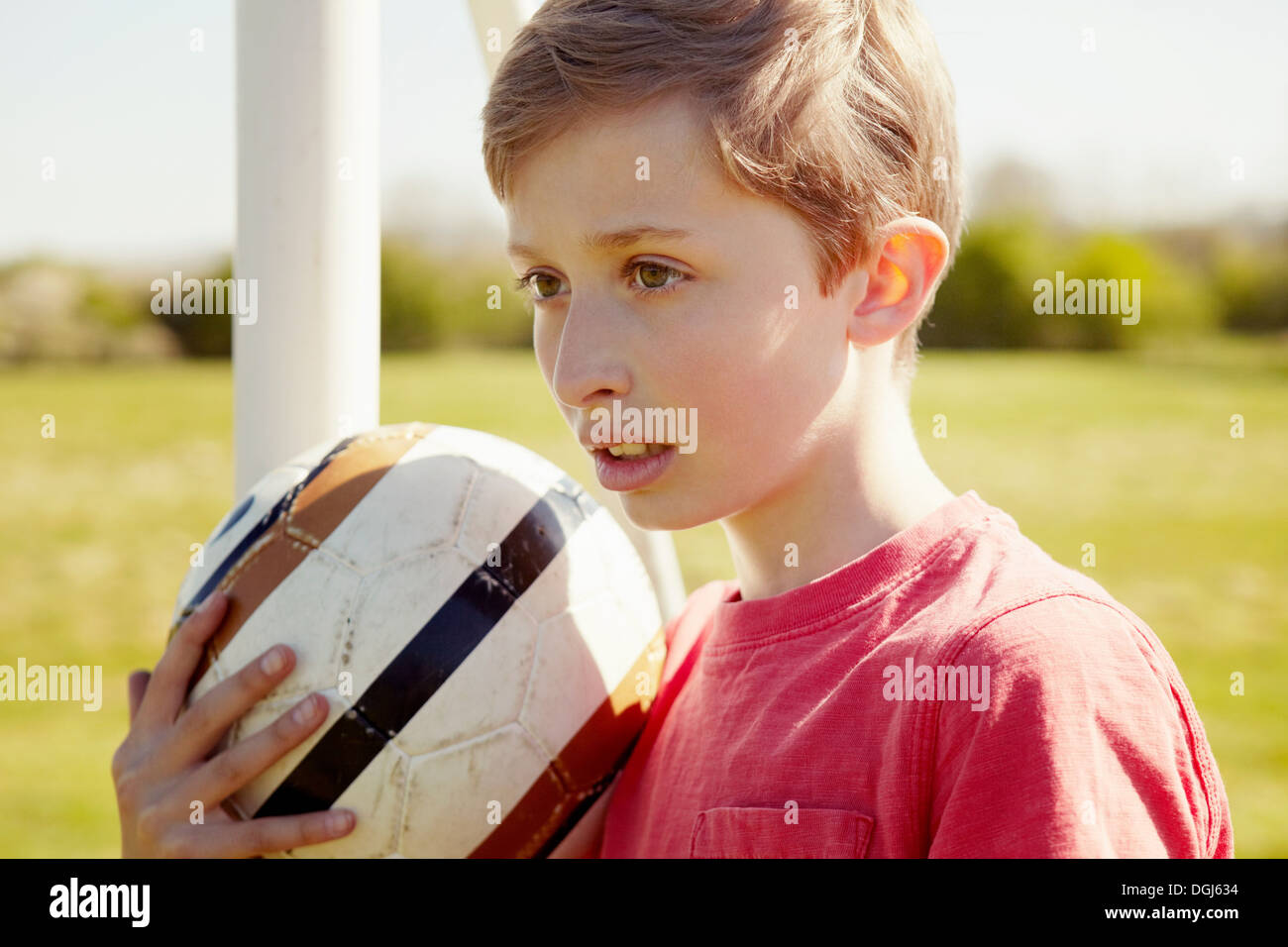 Boy with ball looking into the distance Stock Photo - Alamy