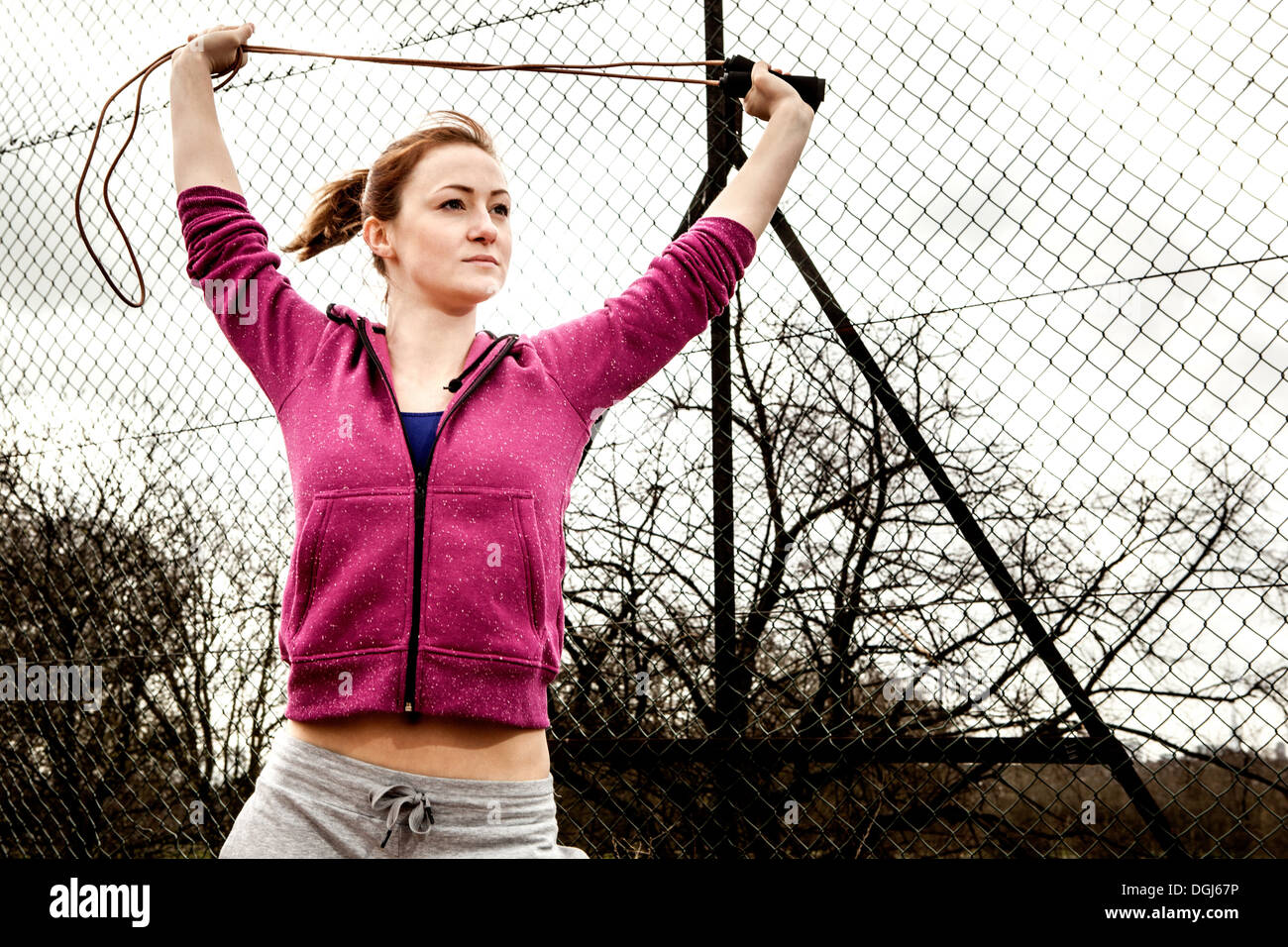 Woman in hoodie stretching pilates rope above head Stock Photo - Alamy