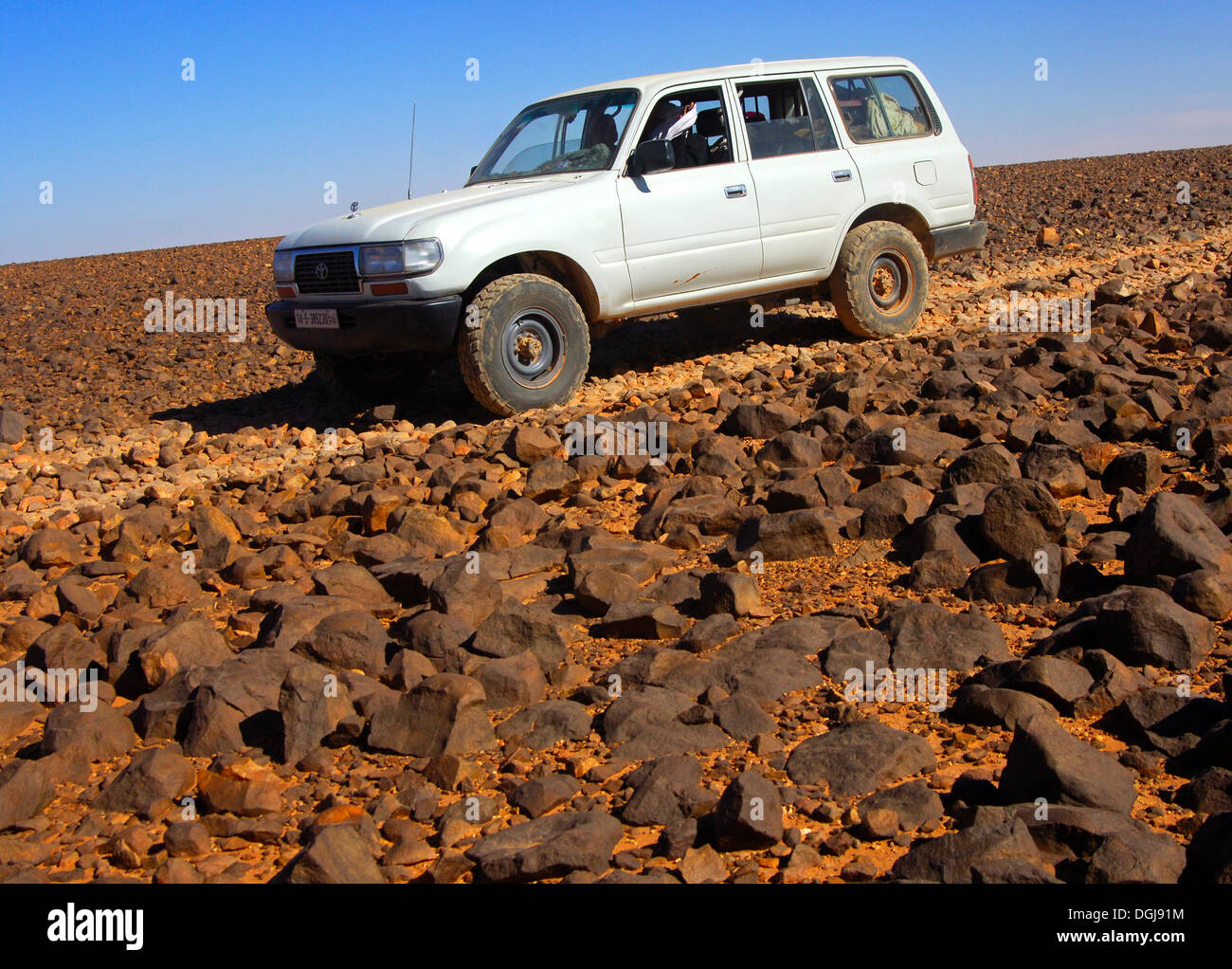 Jeep in the stony desert landscape on the Messak Settafek plateau ...