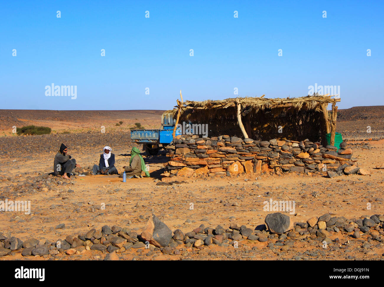 Three Bedouin men sitting next to their simple dwelling on the Mesak ...