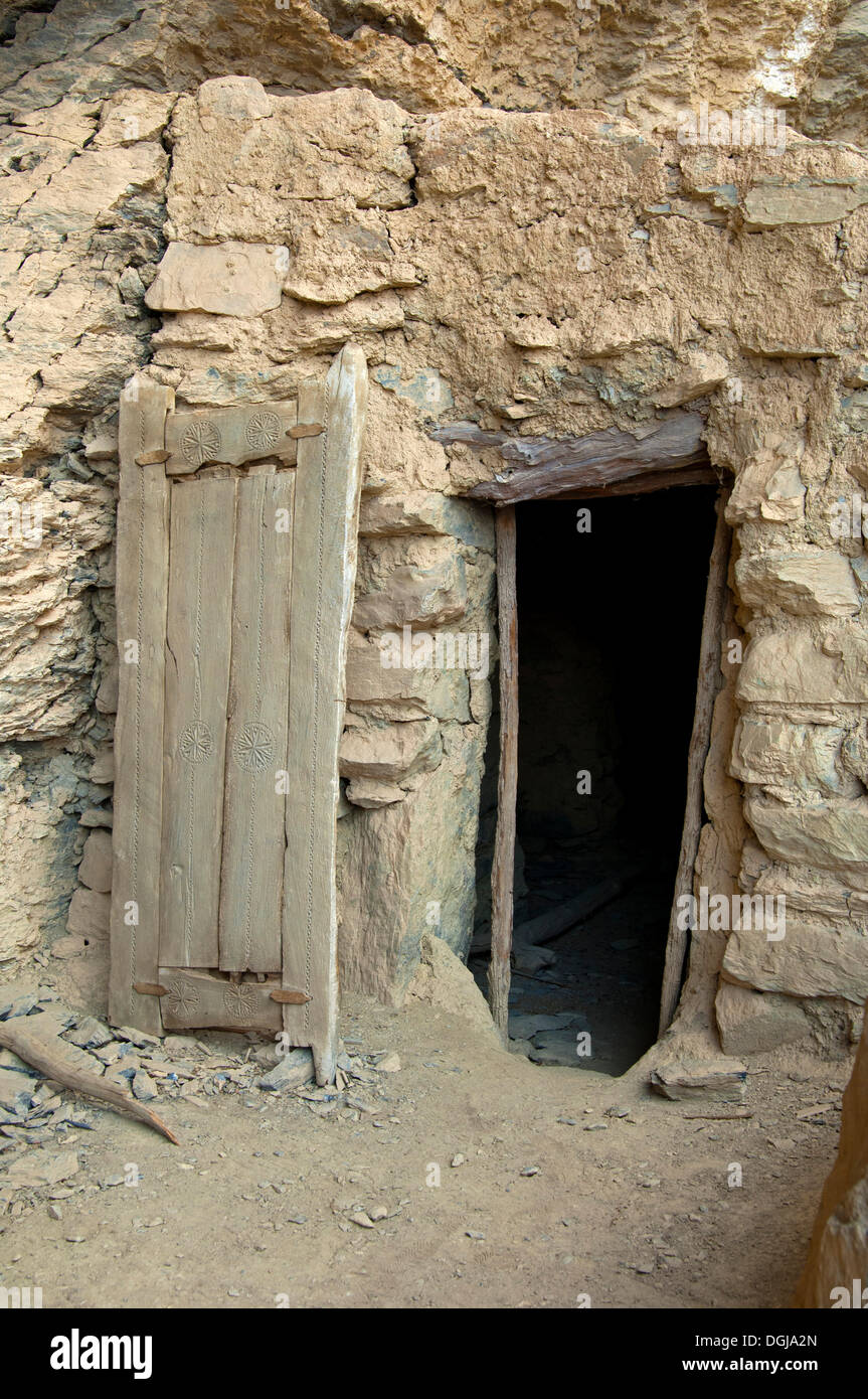 Entrance with a carved wooden door to a stone hut at the abandoned ...