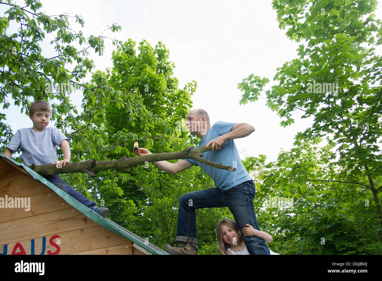 Father and two children climbing on playhouse roof Stock Photo - Alamy