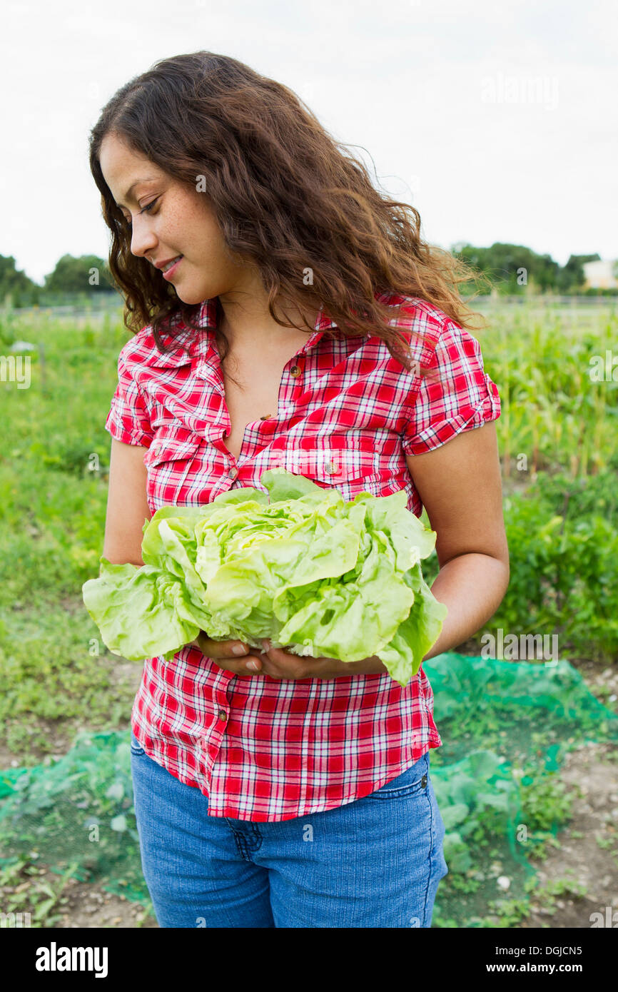 Young woman holding cabbage in allotment Stock Photo - Alamy