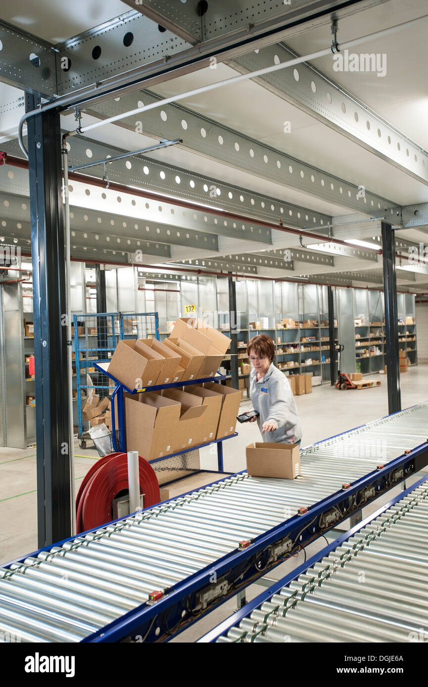 Female warehouse worker placing box onto conveyor belt Stock Photo - Alamy