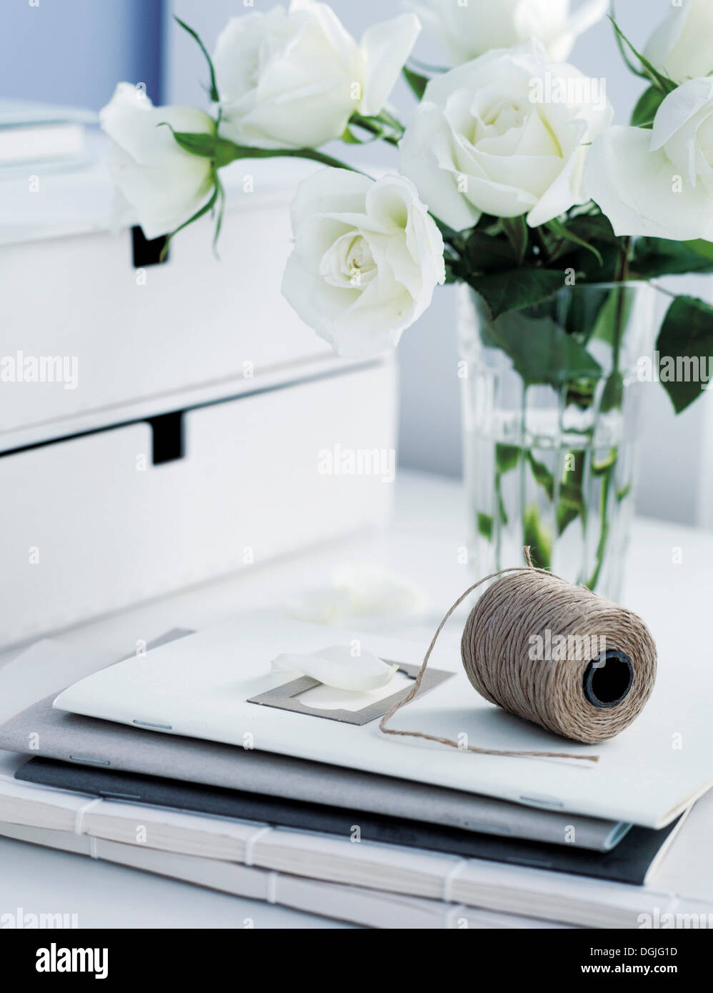 White roses in vase with ball of string, still life Stock Photo - Alamy
