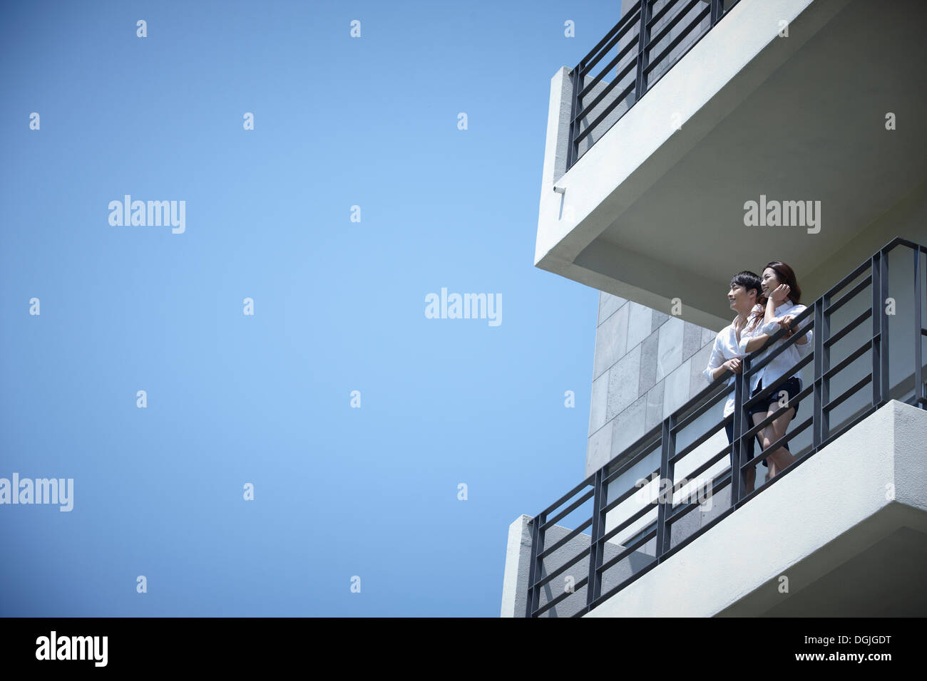 Couple standing on a balcony hi-res stock photography and images - Alamy