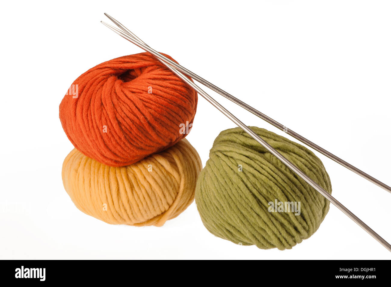 Three woll balls in white background with needles Stock Photo - Alamy
