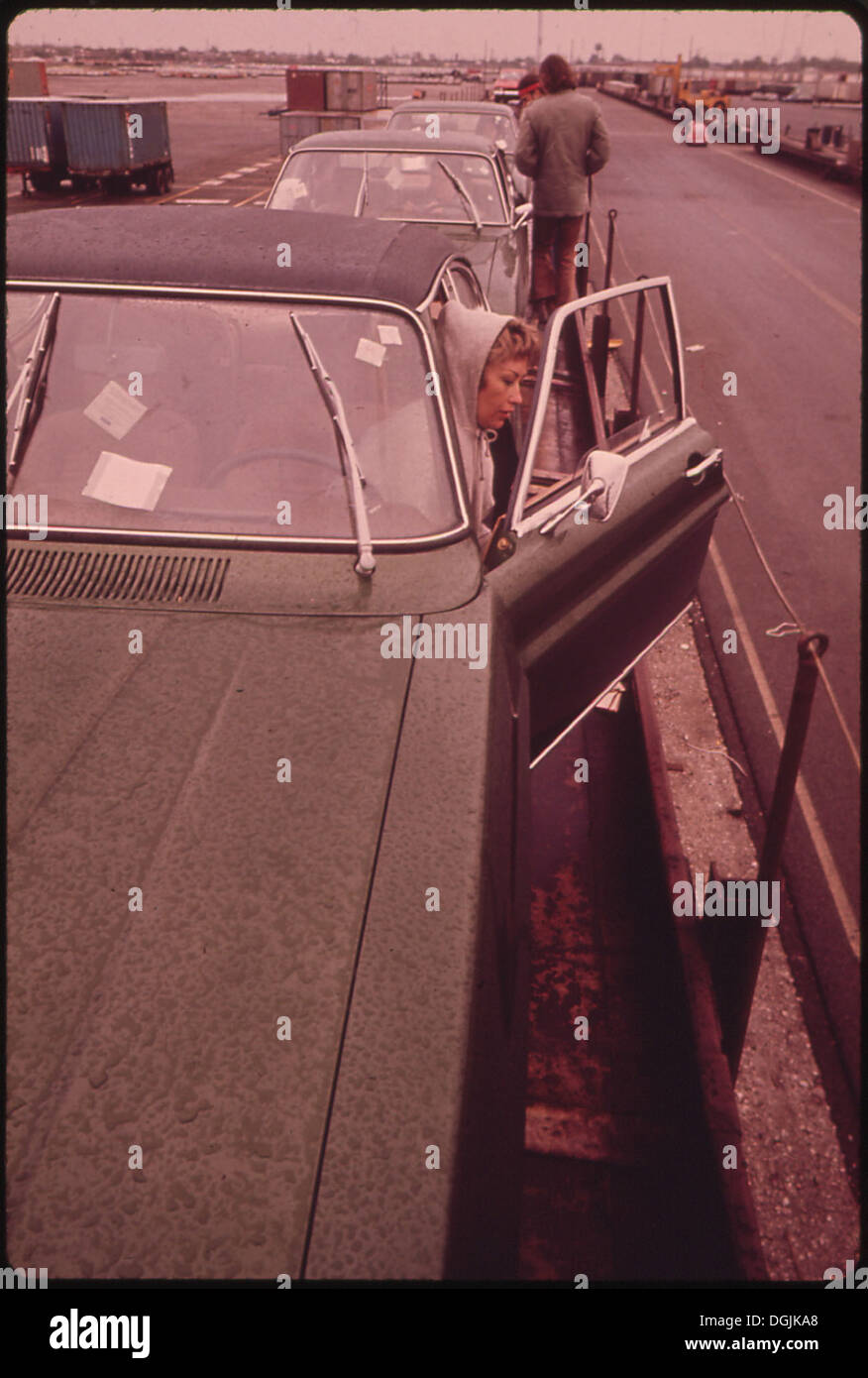 Women workers are seen loading cars onto freight carriers at the ...