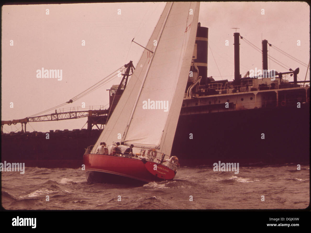The racing sloop Wandelaar passes close by a large cargo ship in ...