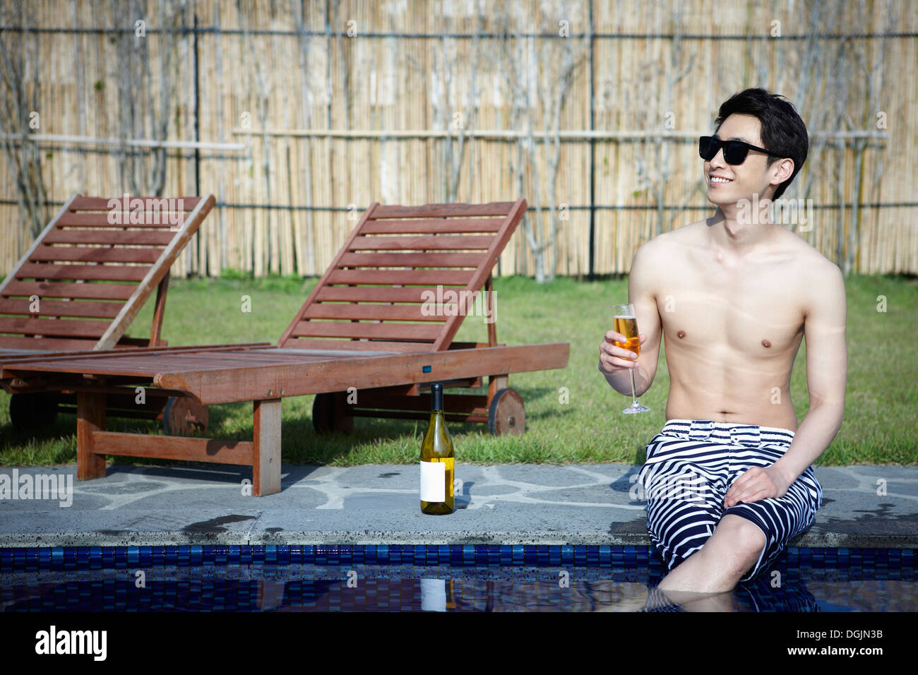 a man sitting next to the pool Stock Photo - Alamy