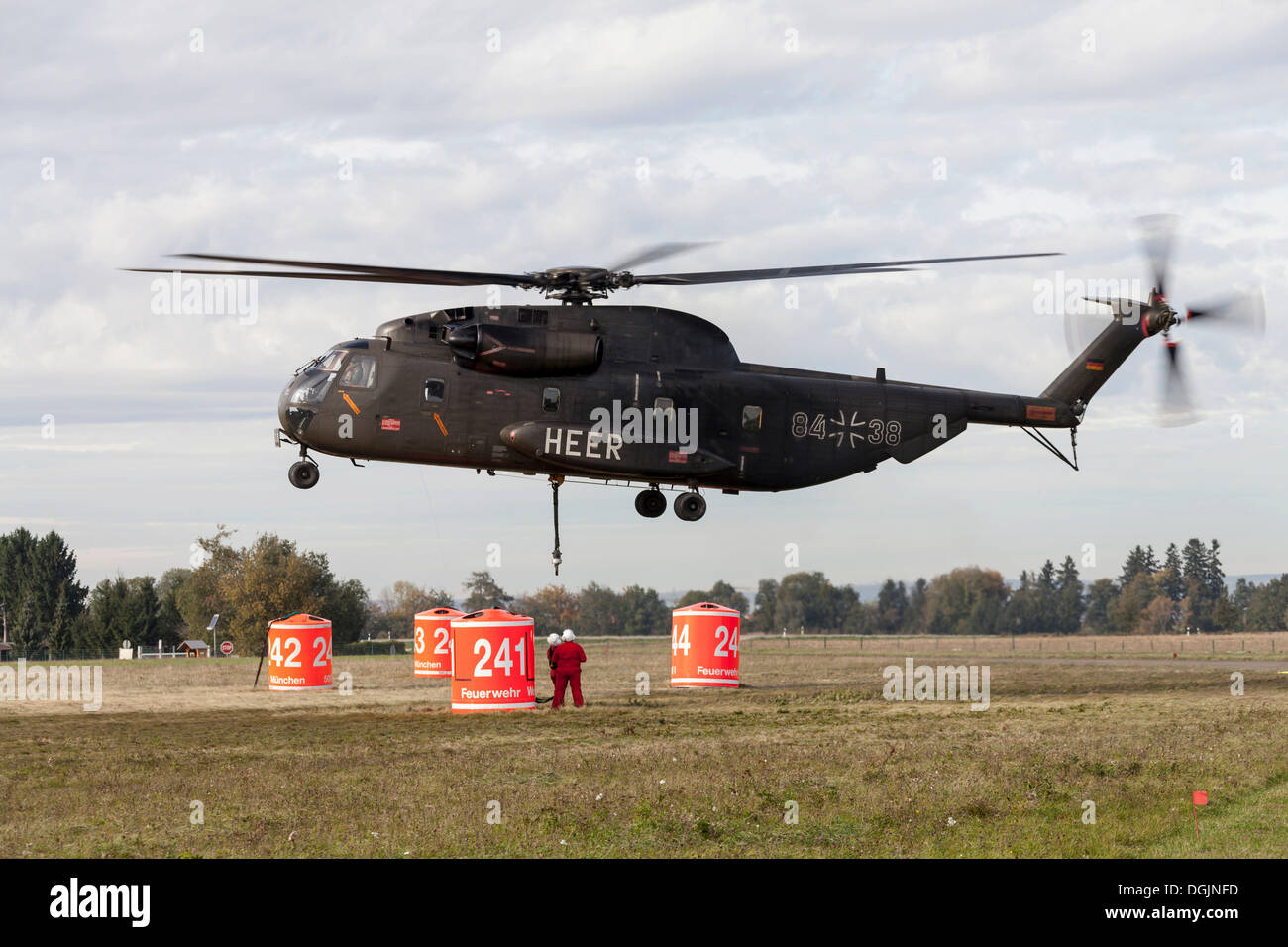 Firefighters hanging a 5000-liter water tank under a CH-53 helicopter ...
