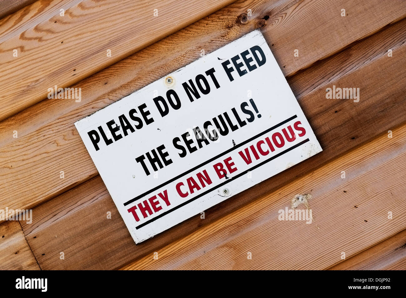 A warning sign on a wooden wall Stock Photo - Alamy