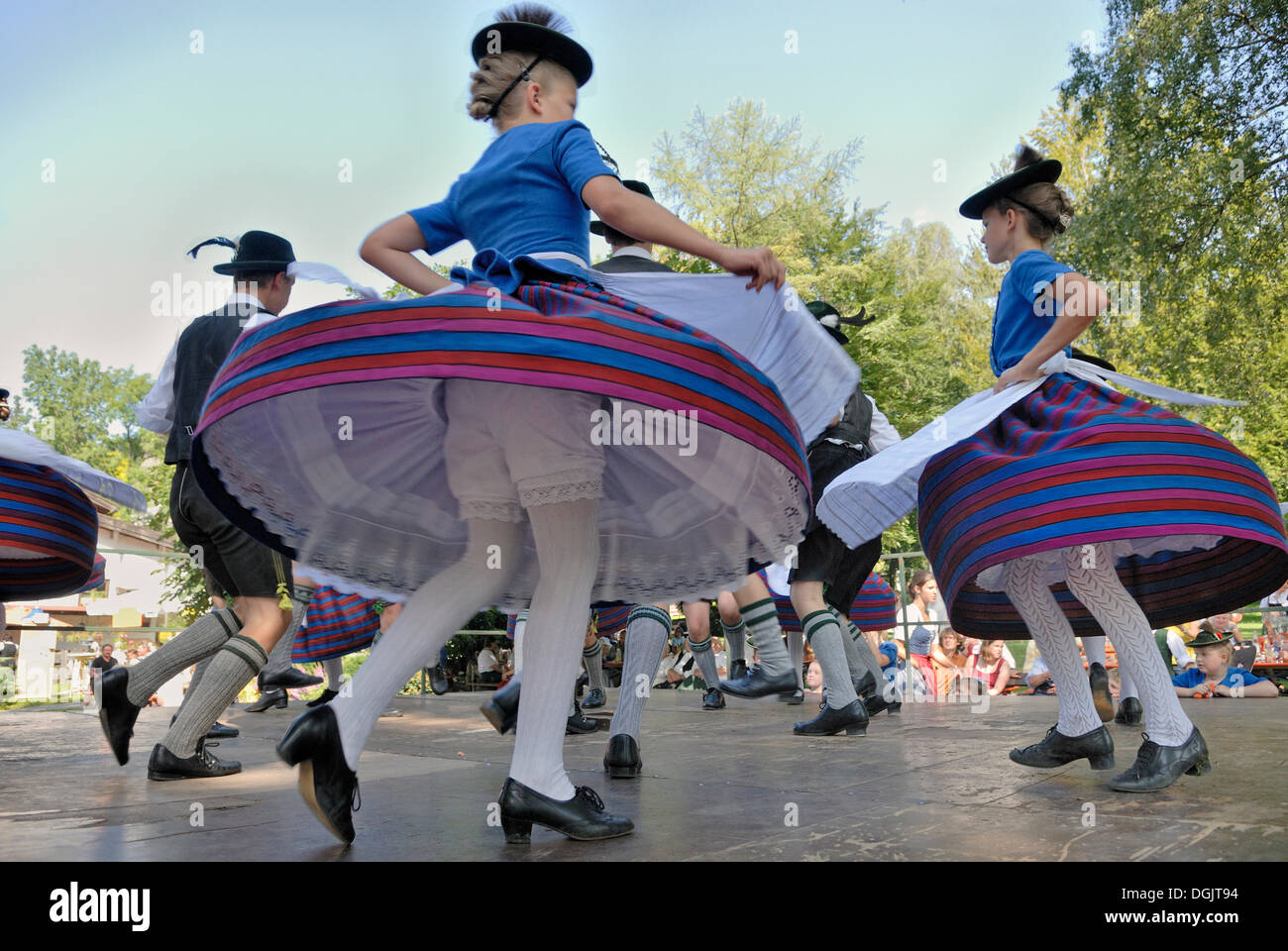 Youth group wearing traditional costumes while dancing a ribbon dance ...