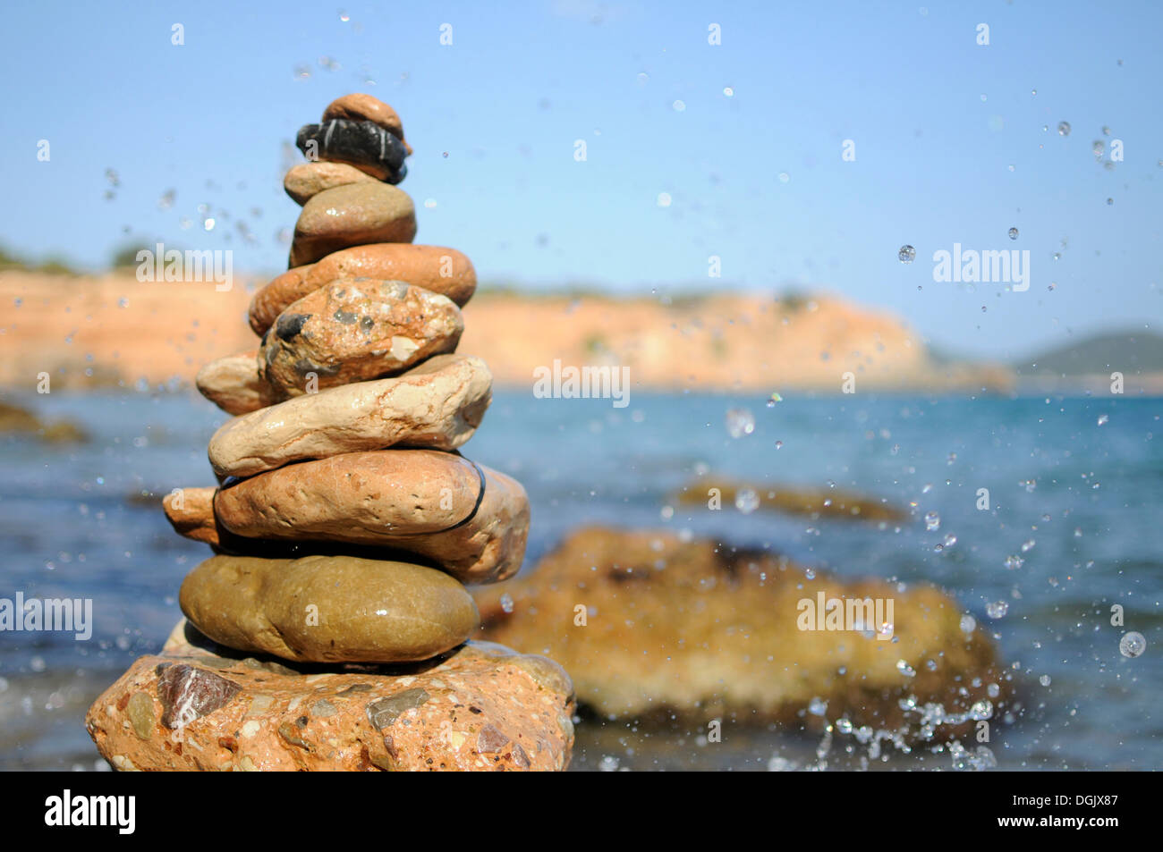 Water hits stone sculpture in Ibiza beach Stock Photo - Alamy