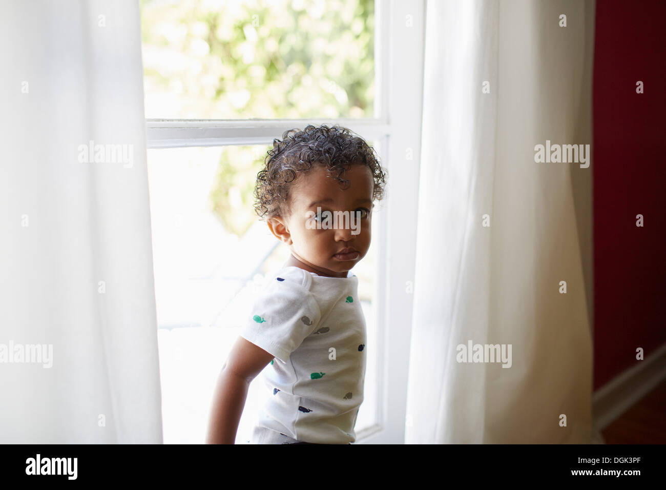Toddler standing beside window Stock Photo - Alamy