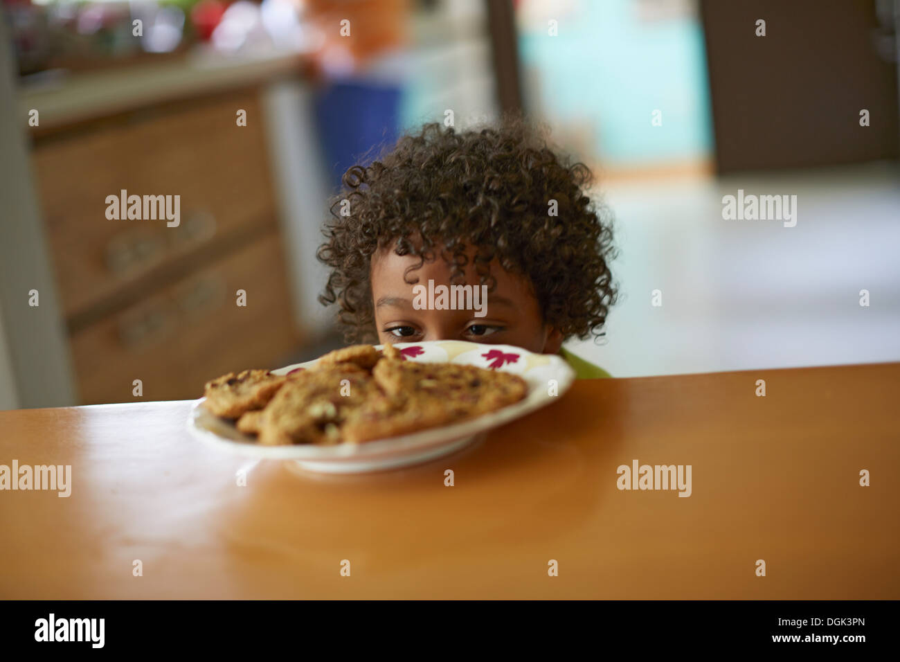 Boy looking at plate of cookies Stock Photo - Alamy