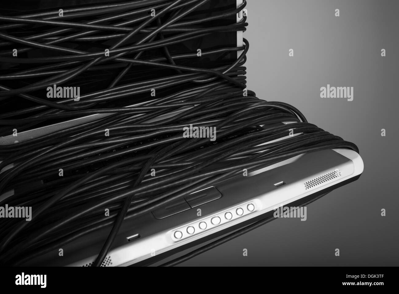 Laptop covered in power cable Stock Photo - Alamy