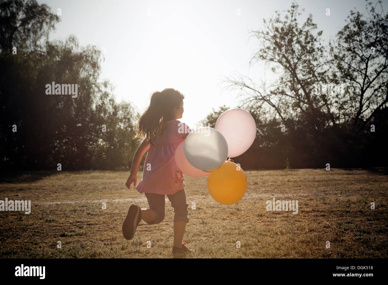Girl running with balloons Stock Photo - Alamy