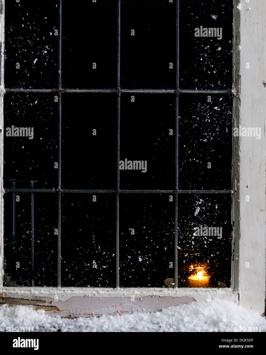 Candle burning in snow covered house window Stock Photo - Alamy