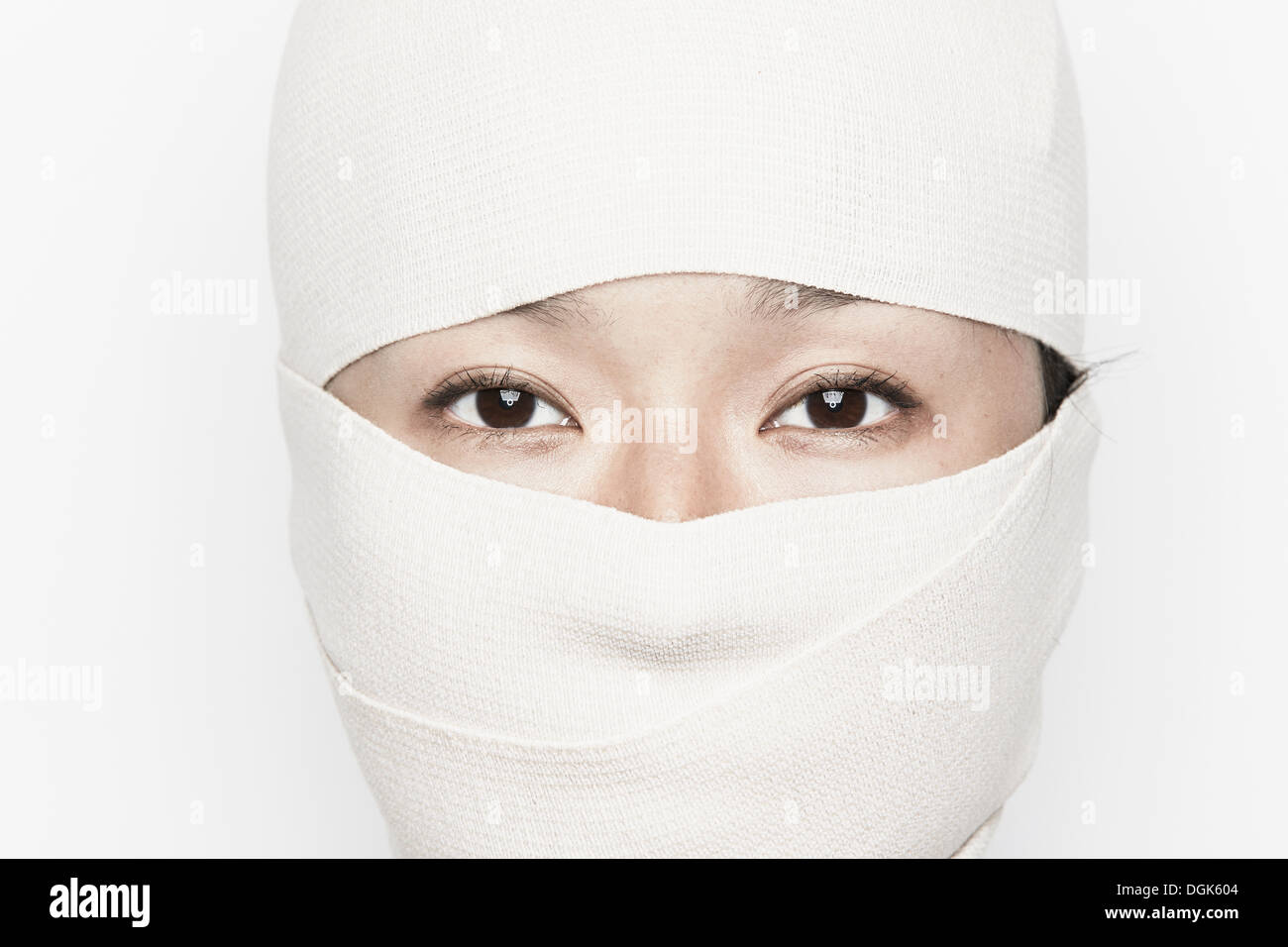 Woman with face bandaged, only eyes visible Stock Photo - Alamy