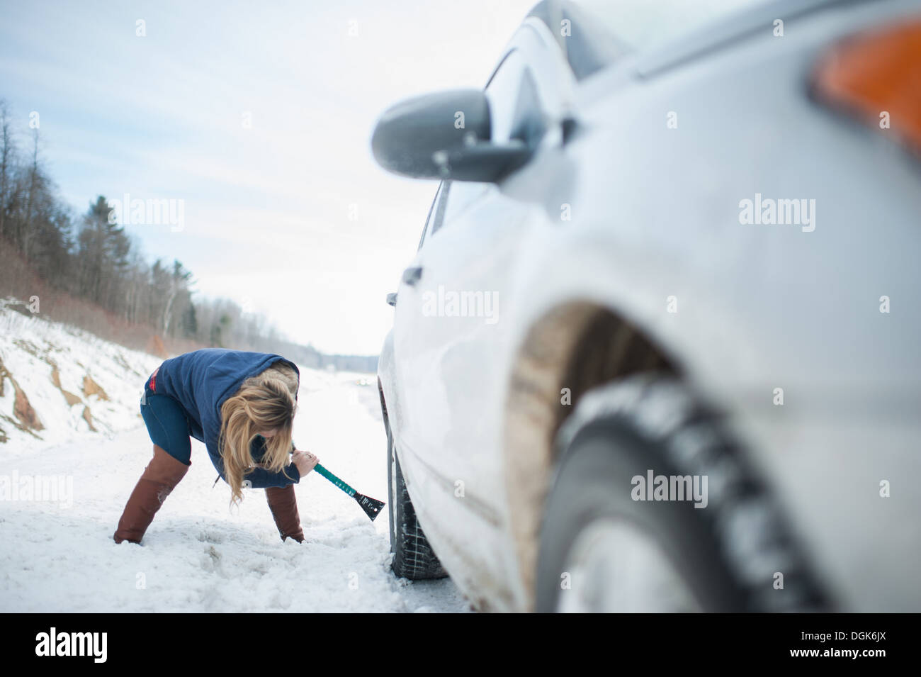 Woman digging car out from snow Stock Photo - Alamy
