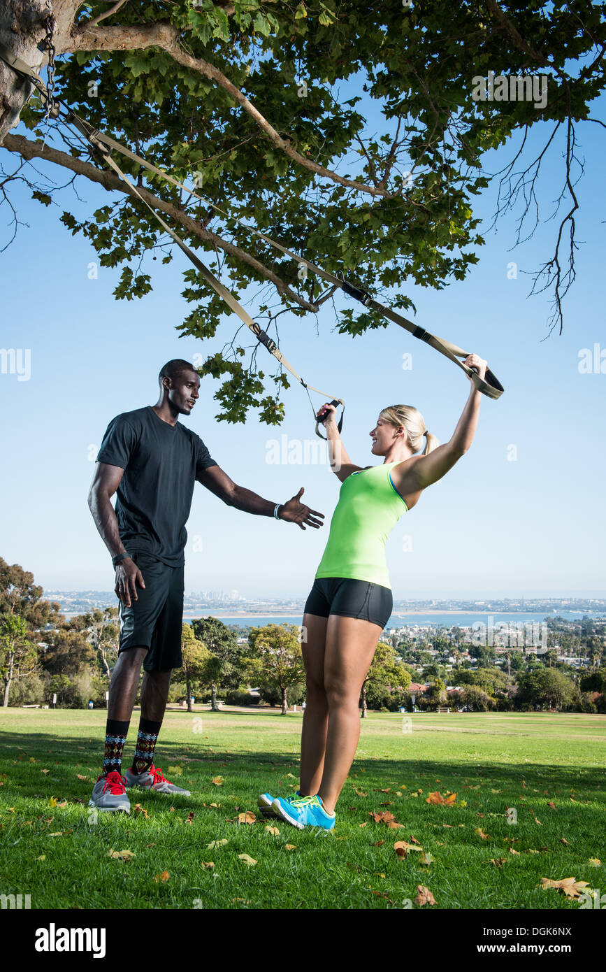 Young woman and trainer using lunge rope in park Stock Photo - Alamy