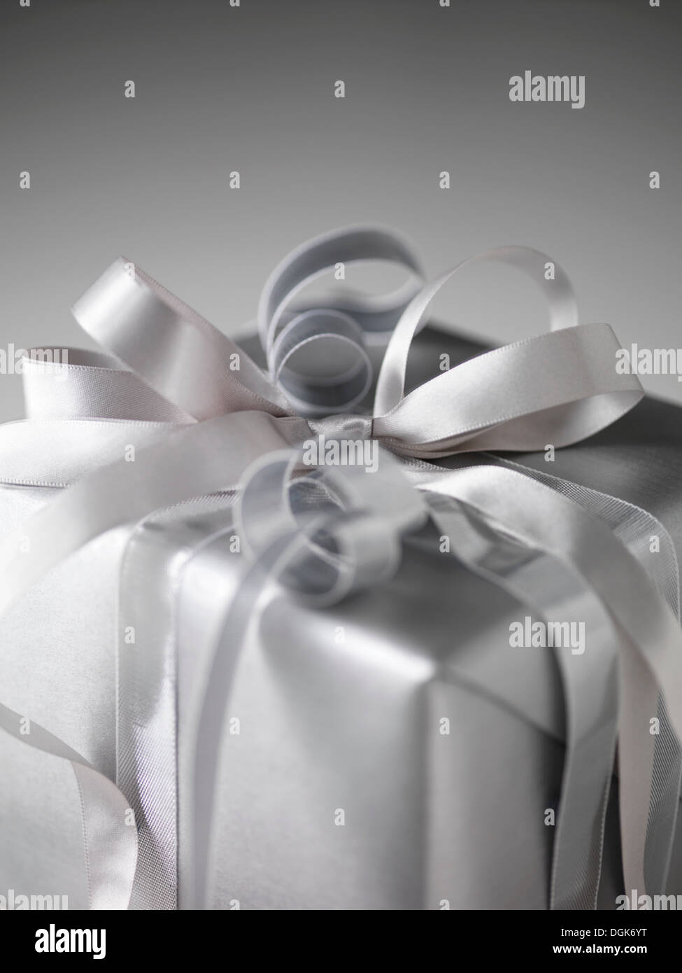 Still life with parcel wrapped in silver paper and ribbons Stock Photo ...