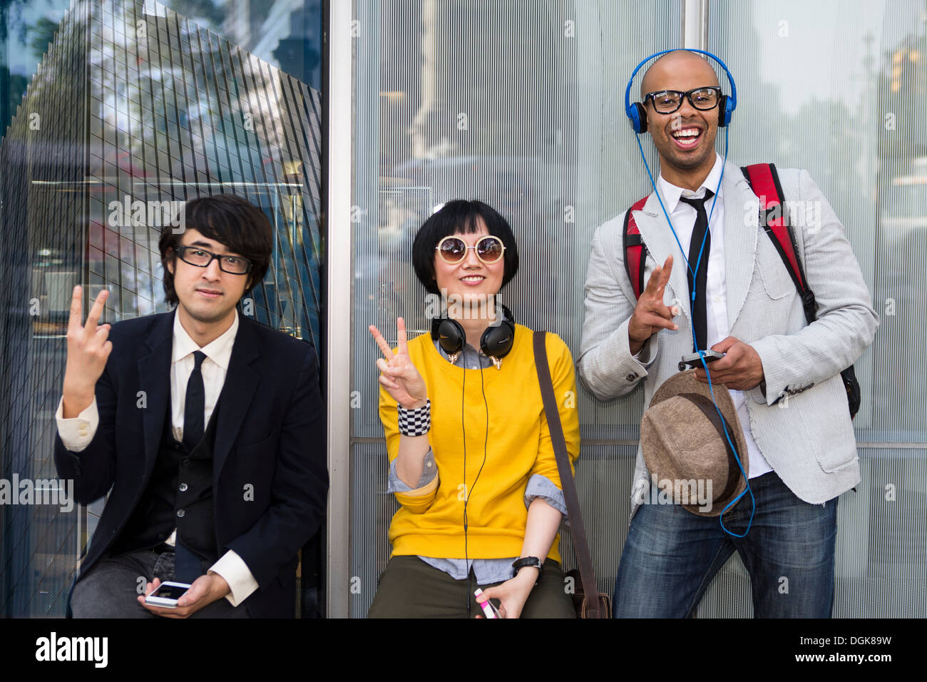 Three friends making victory sign Stock Photo - Alamy