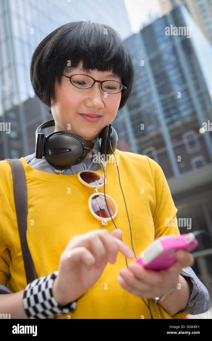 Young woman wearing yellow top using mp3 player Stock Photo - Alamy