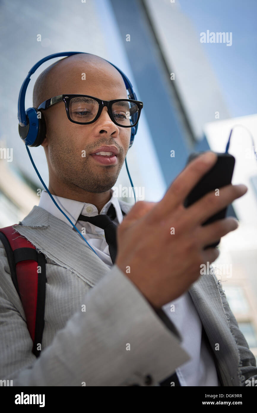 Young man wearing headphones and glasses using mp3 player Stock Photo ...