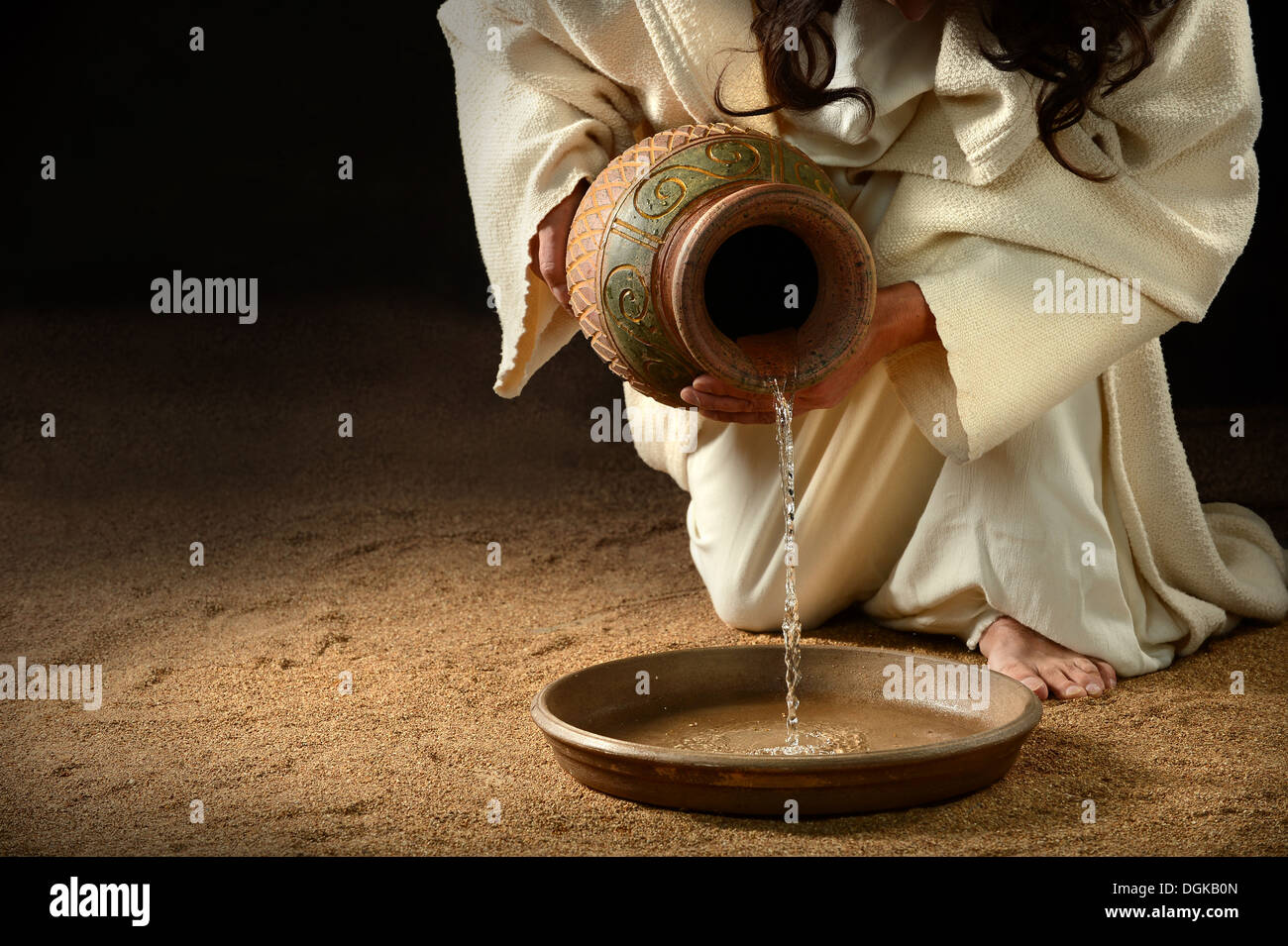 Jesus pouring water from jug to pan to wash feet of disciples Stock ...