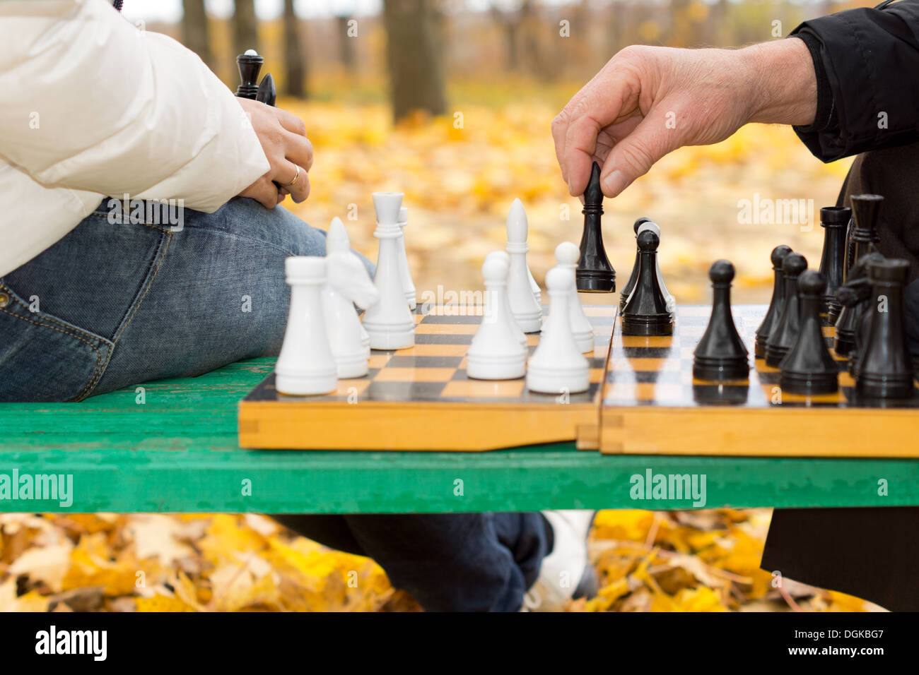 Close up of the hands of an elderly man making a chess move lifting a ...