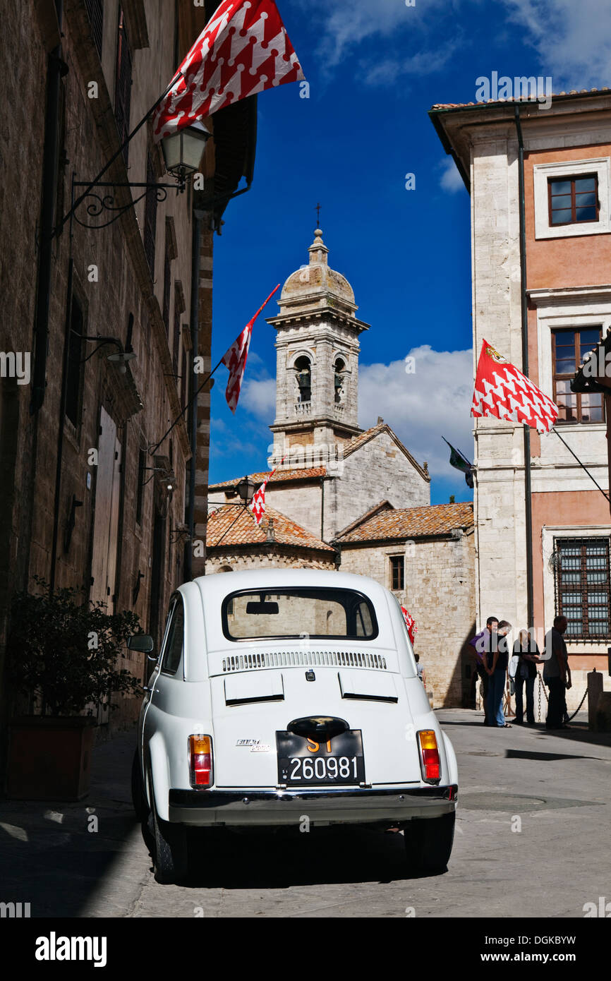 A vintage Fiat 500 car parked on the medieval streets of San Quirico d ...
