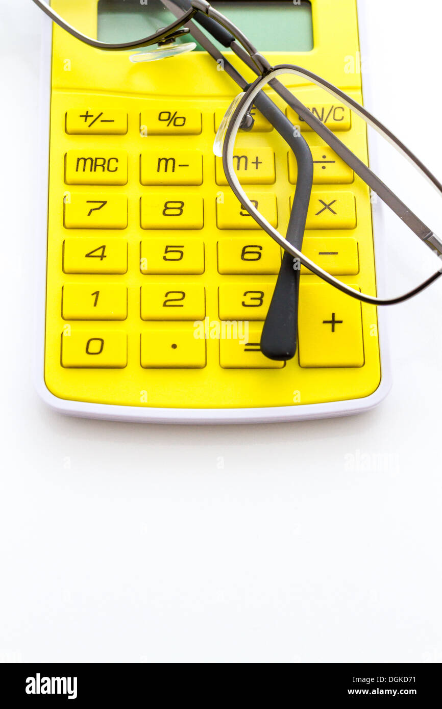 Simple yellow calculator with reading glasses on a white background ...
