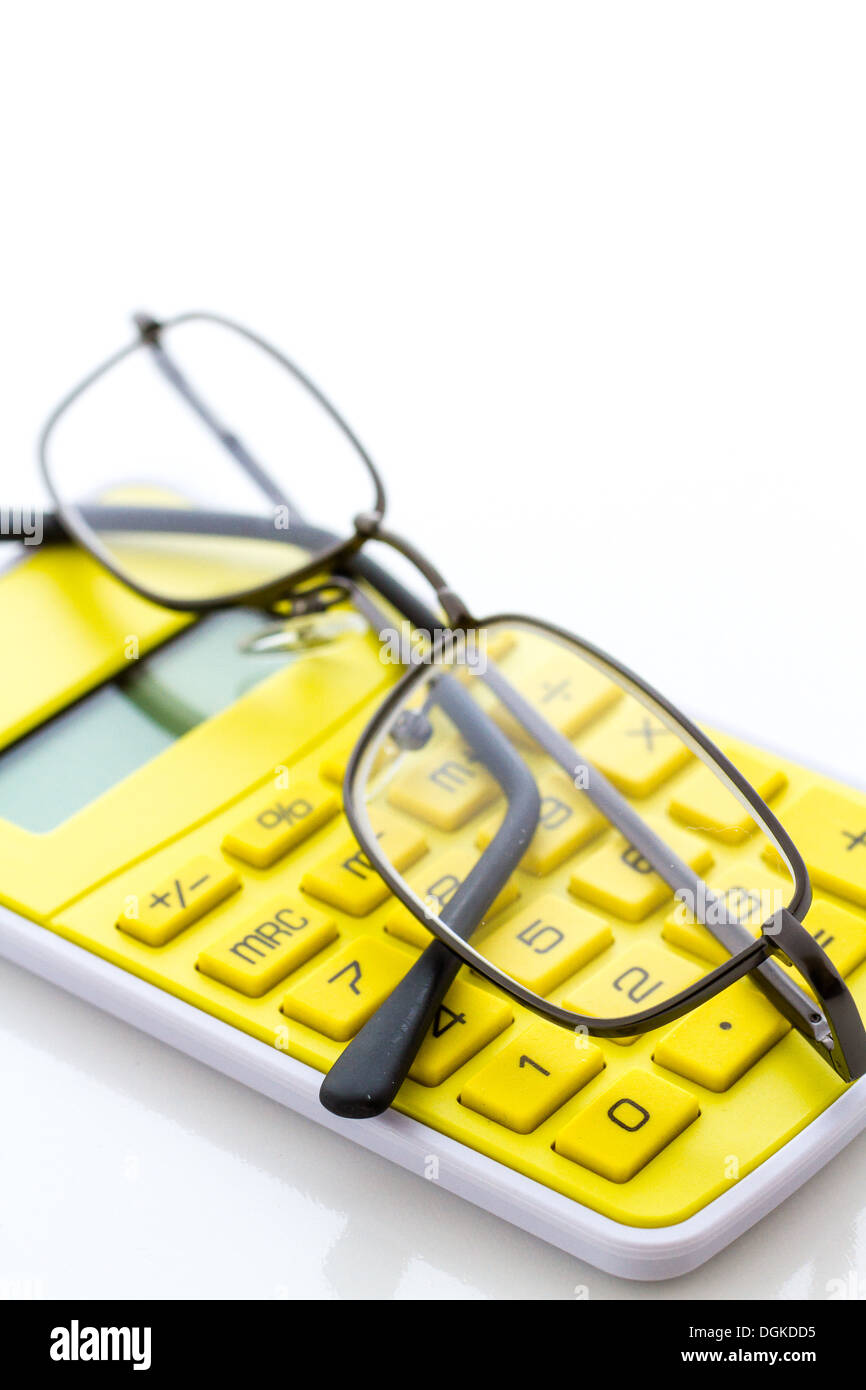 Simple yellow calculator with reading glasses on a white background ...