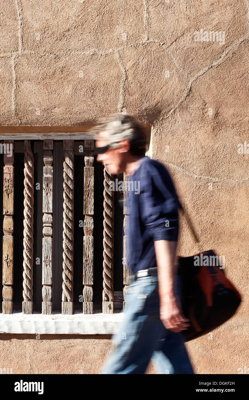 A man walks by an adobe house in Santa Fe Stock Photo - Alamy