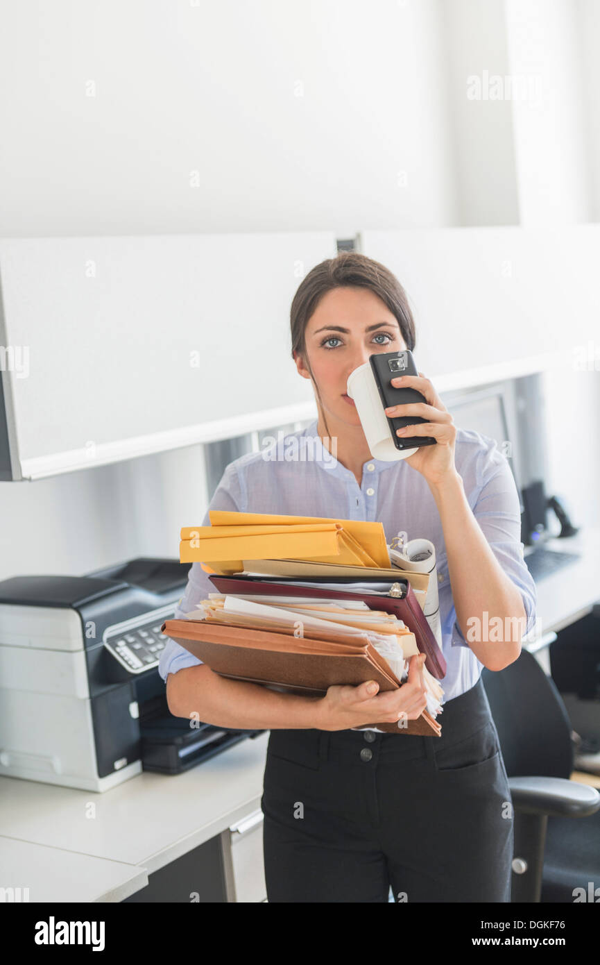 Business woman holding stack of documents and drinking coffee Stock ...