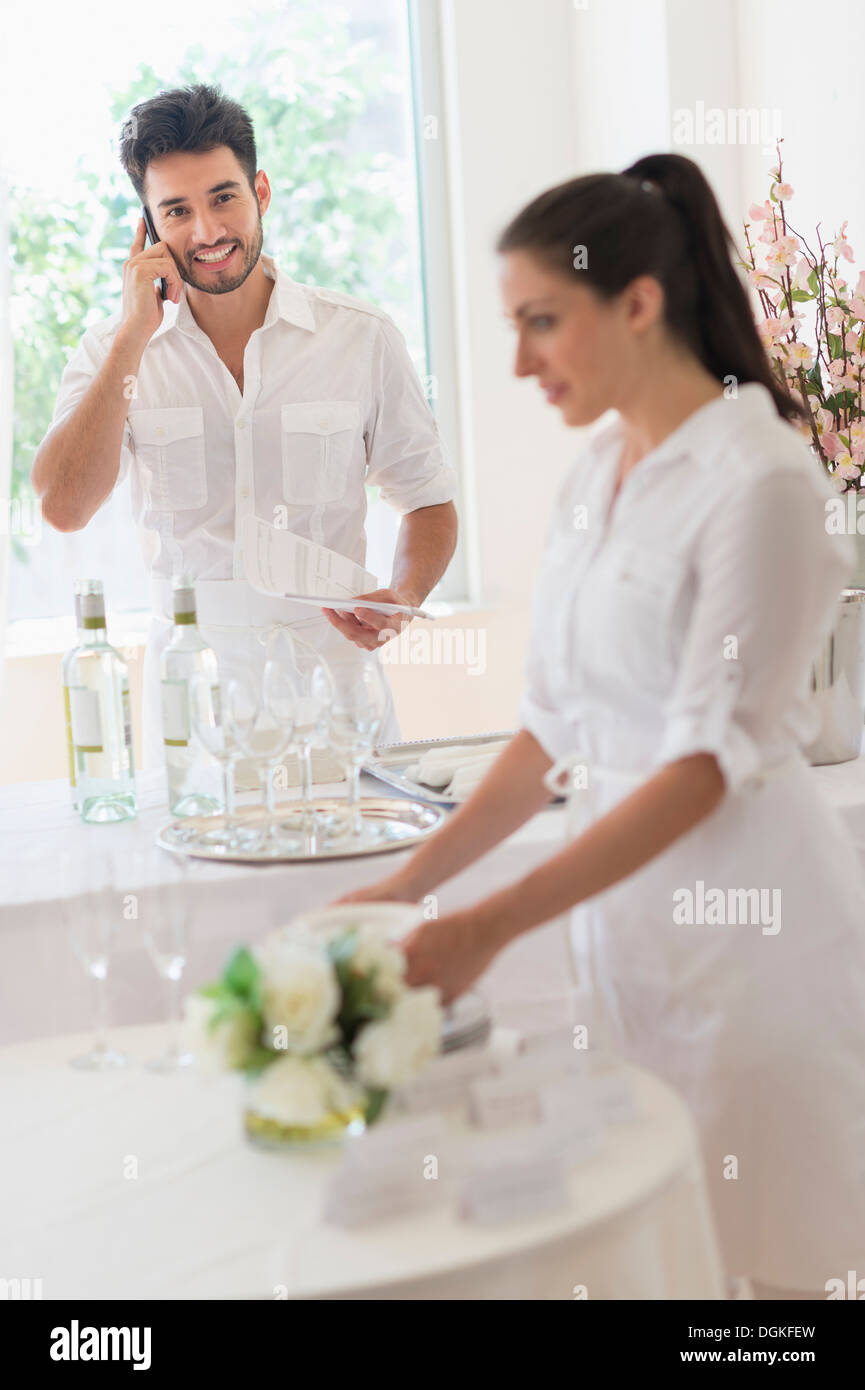 Business owners preparing dining table Stock Photo - Alamy