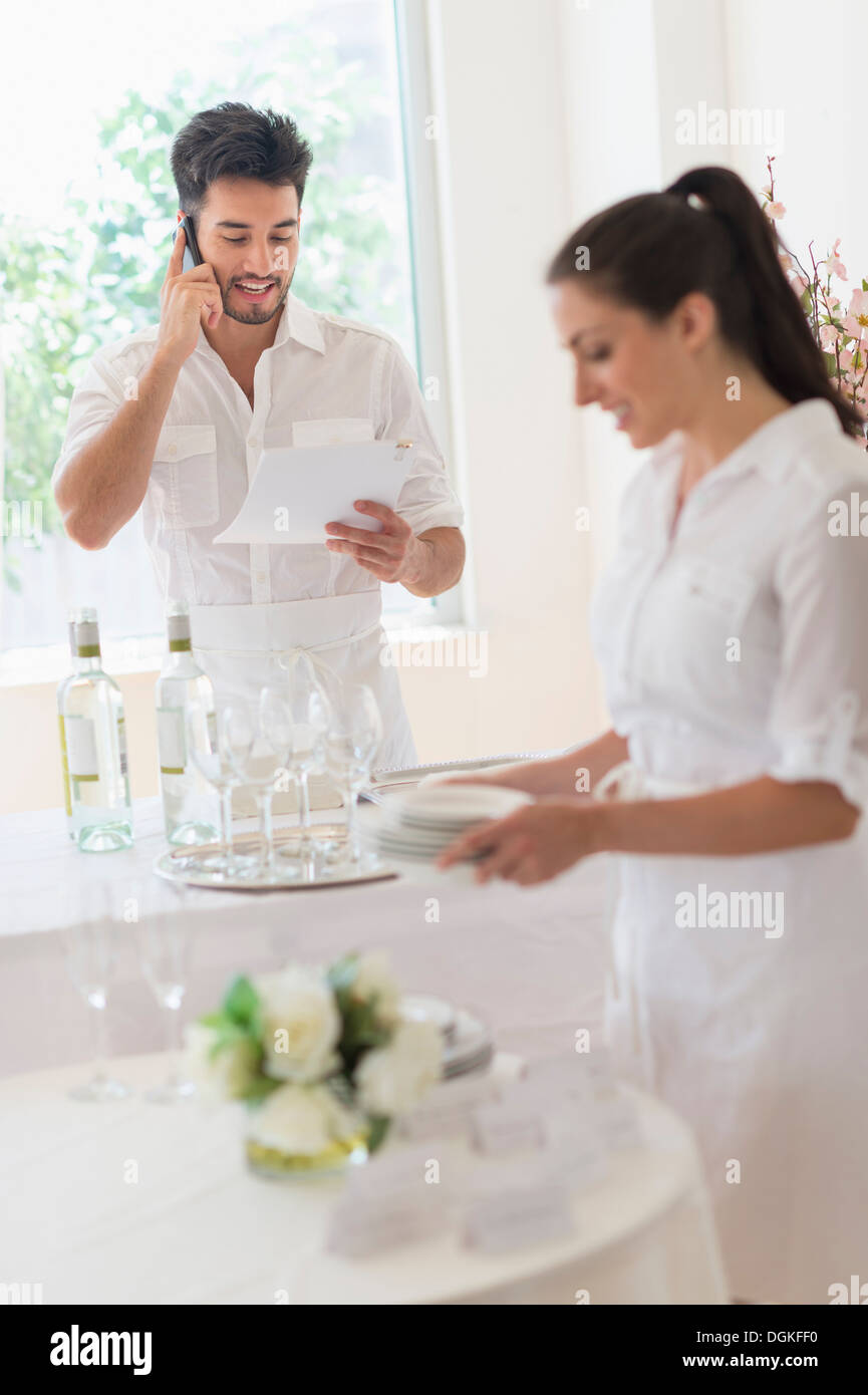 Business owners preparing dining table Stock Photo - Alamy