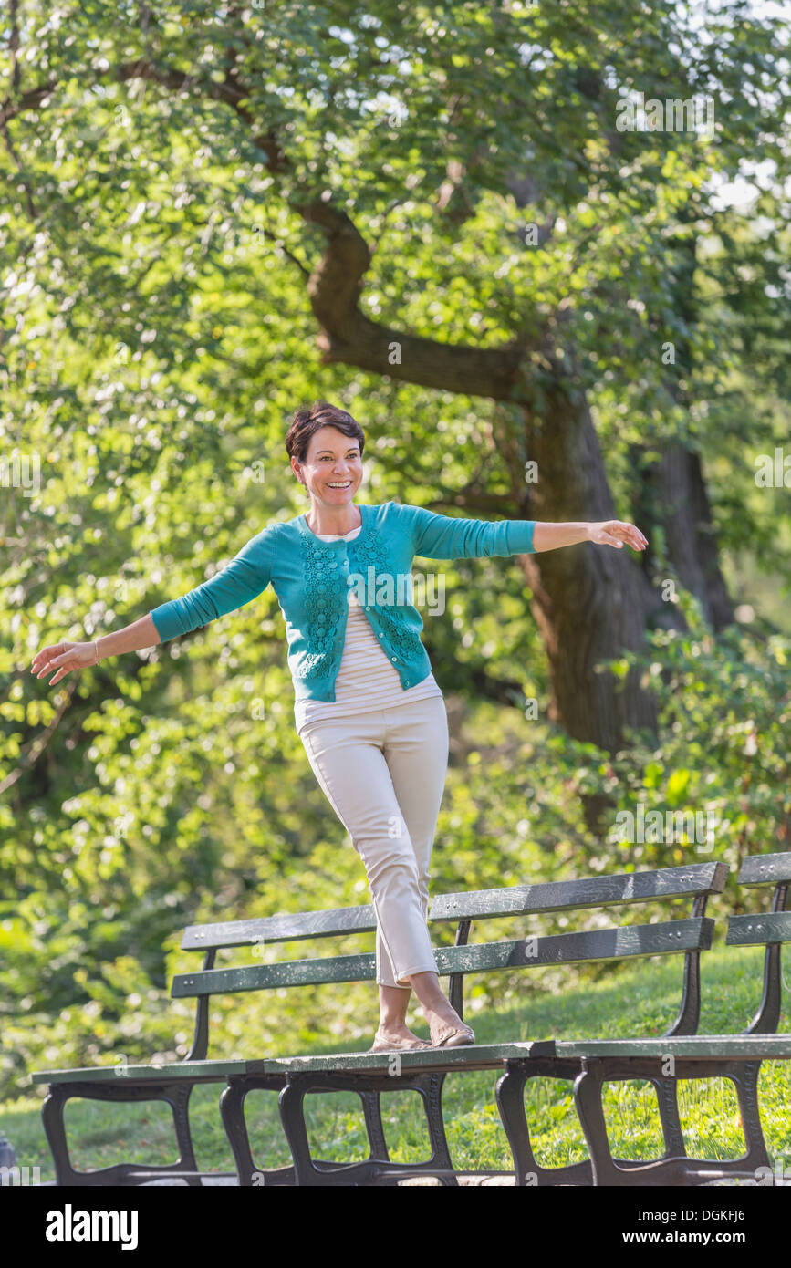 Mature woman walking on bench Stock Photo - Alamy