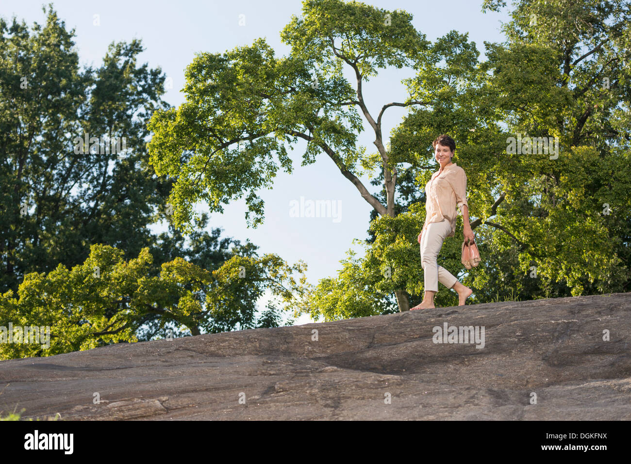 Mature woman walking on rock Stock Photo - Alamy