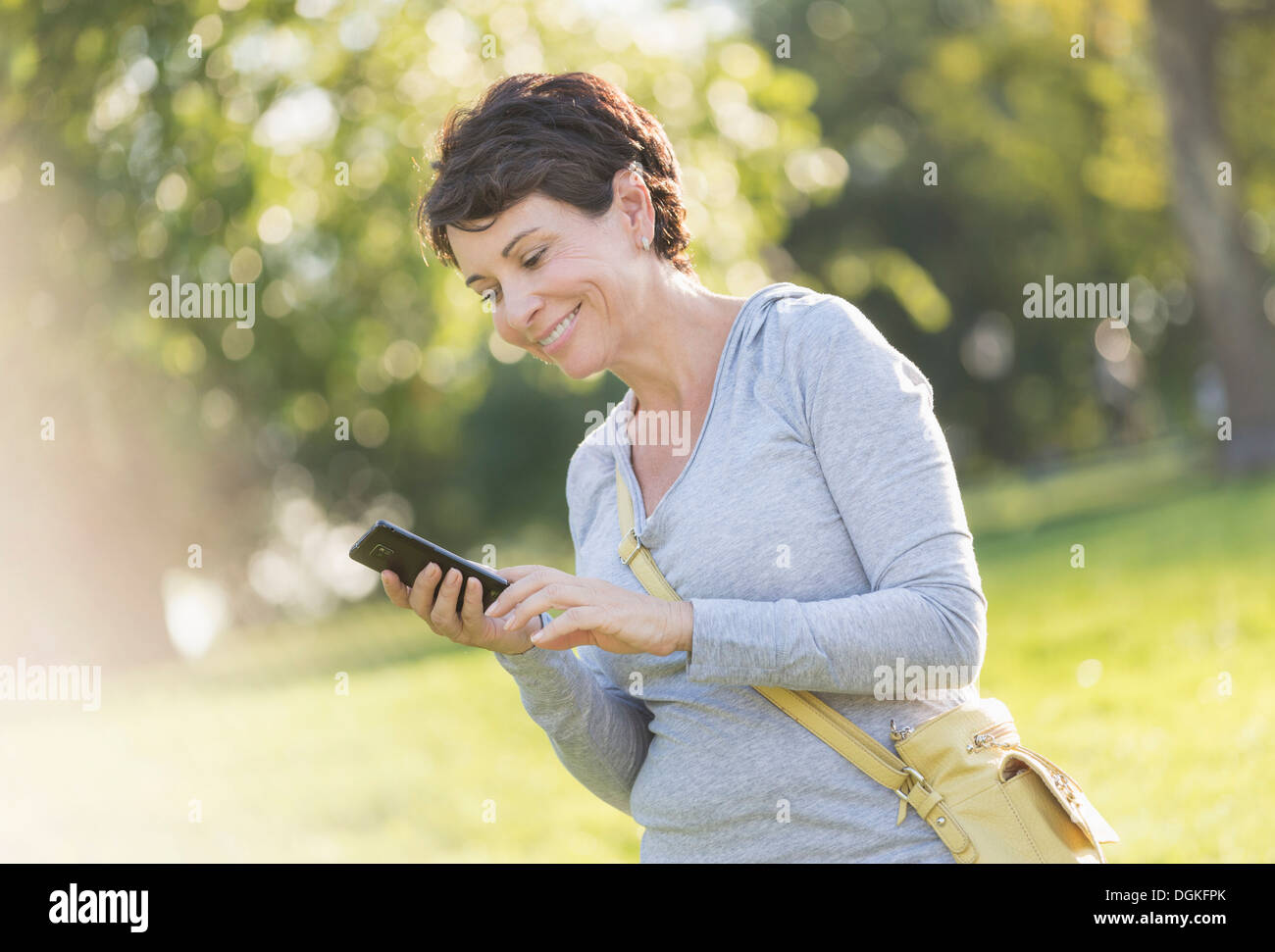 Mature woman text messaging outdoors Stock Photo - Alamy