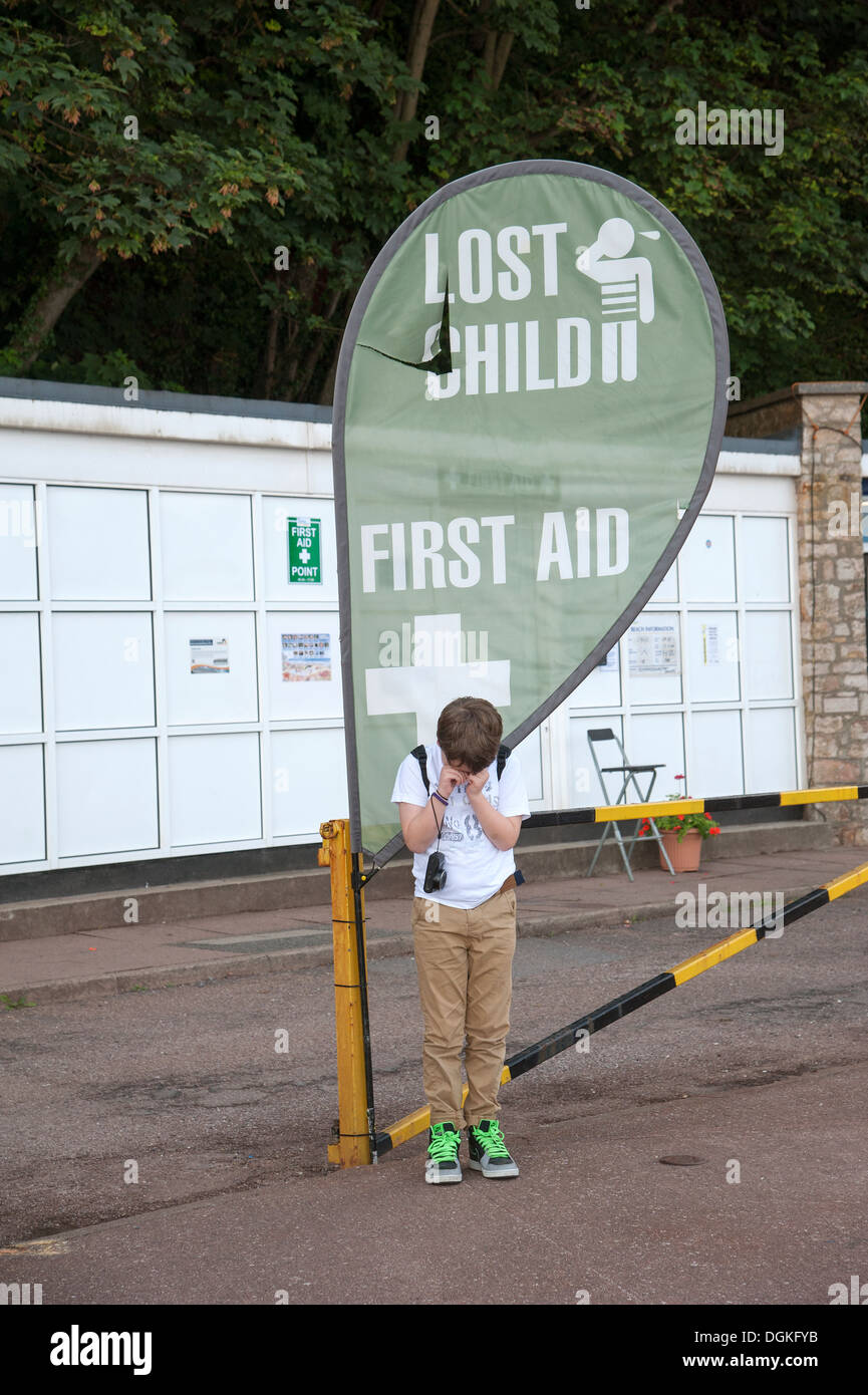 Lost child waiting by lost children sign Stock Photo - Alamy
