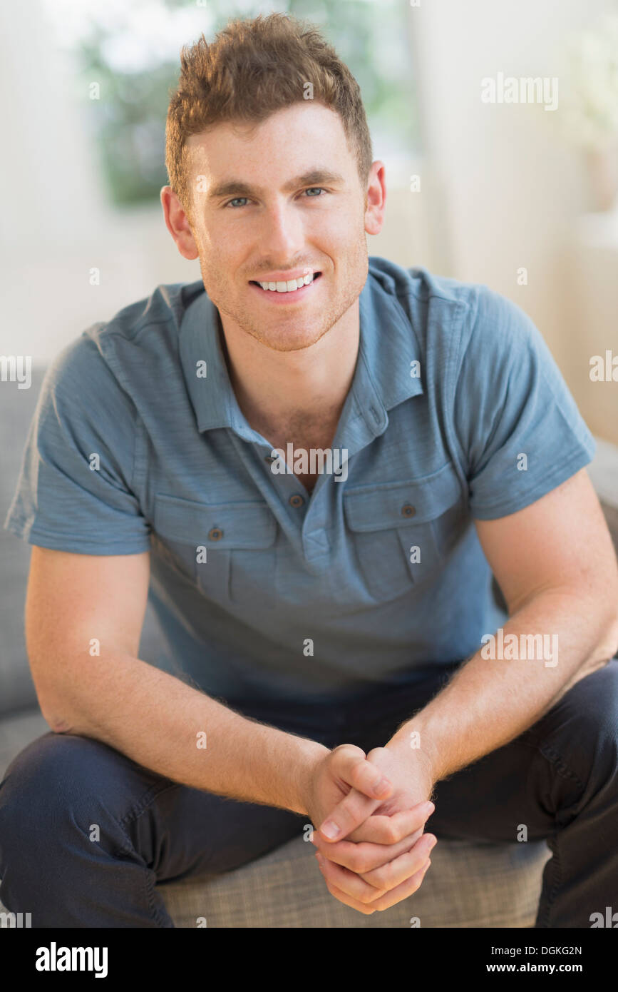 Young smiling man sitting indoors hi-res stock photography and images ...