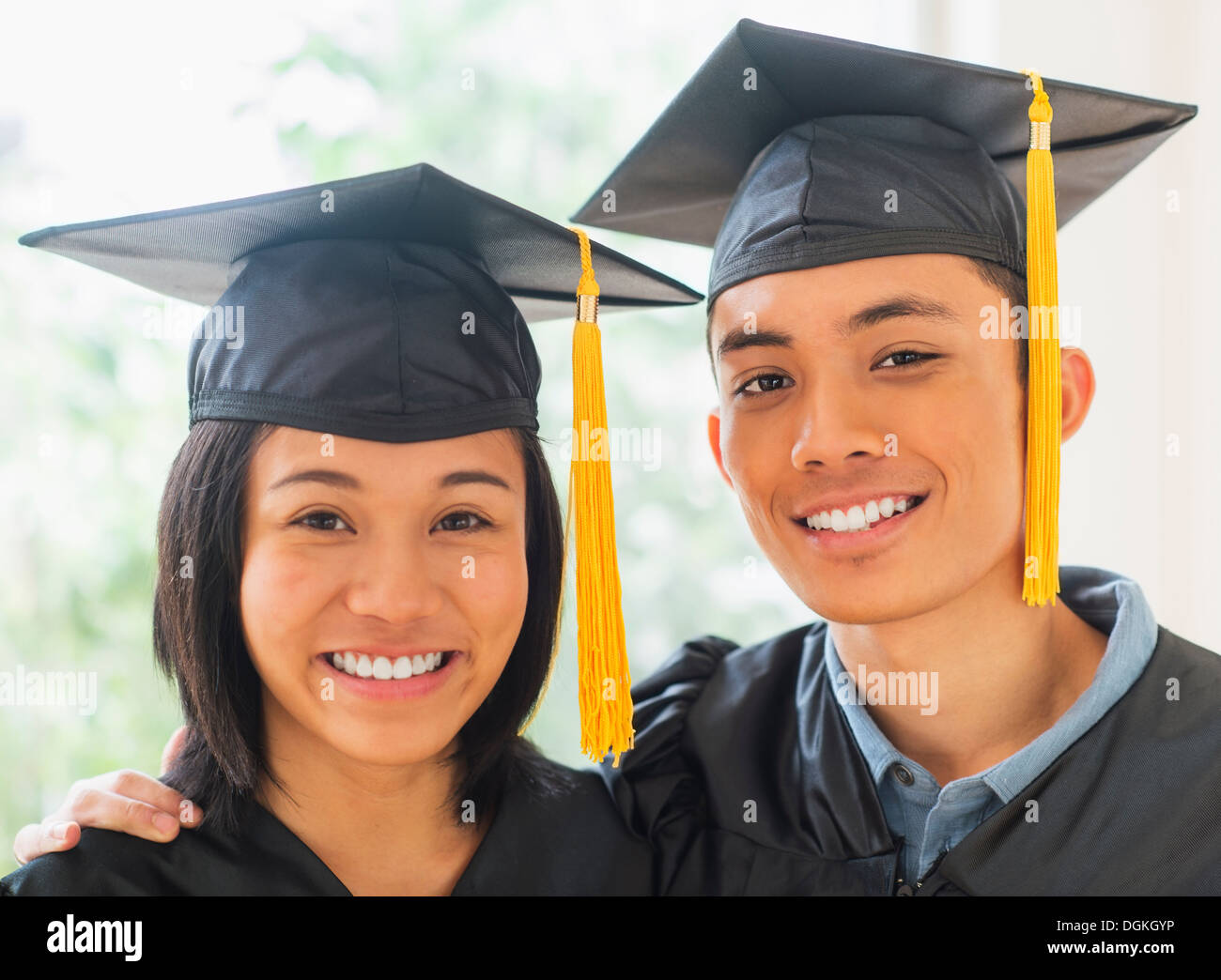 Portrait of young woman and young man wearing graduation gown Stock ...