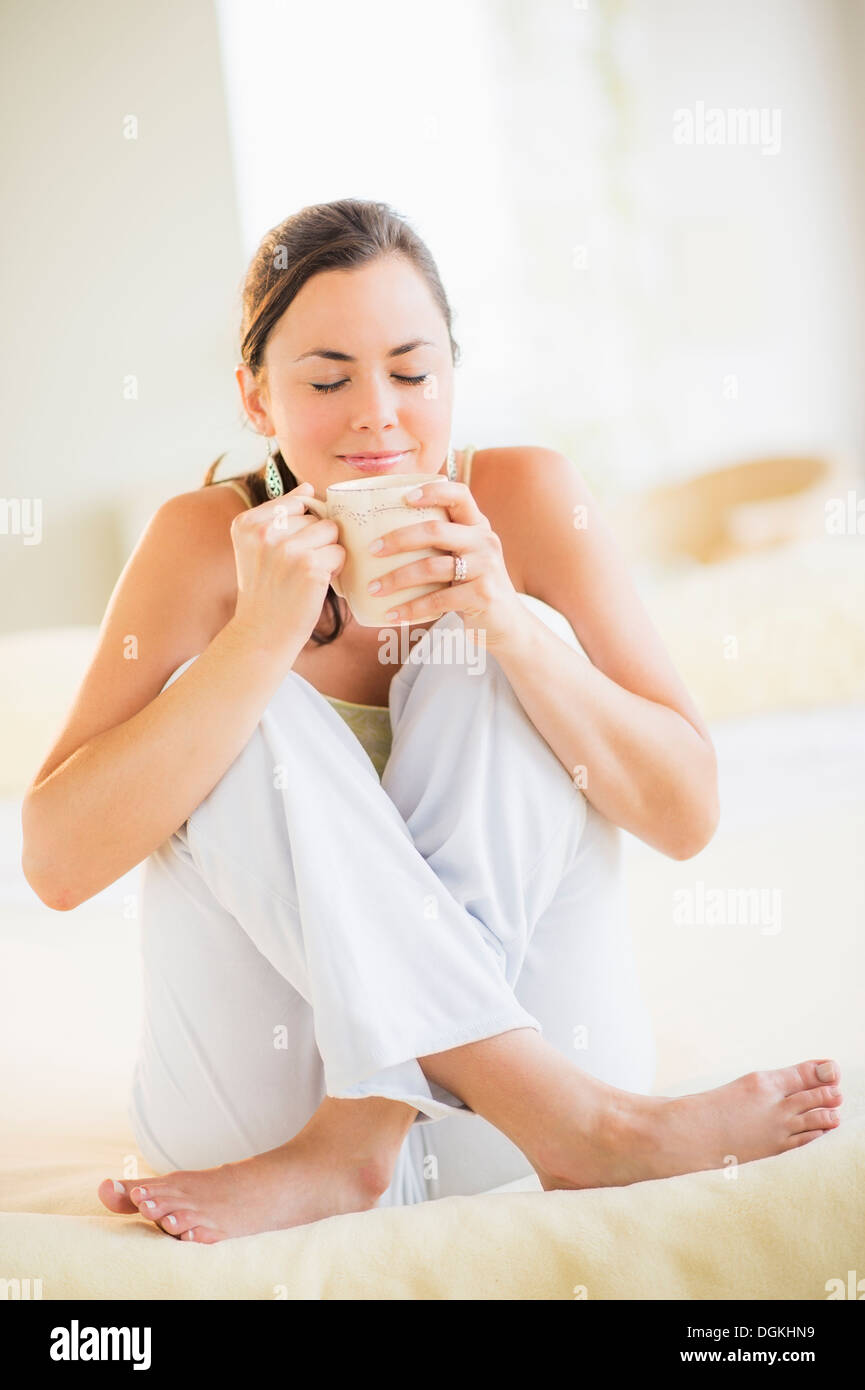Portrait of woman enjoying tea in bed Stock Photo - Alamy