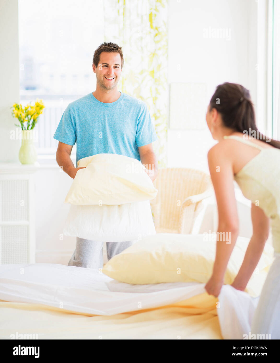 Couple making bed Stock Photo - Alamy