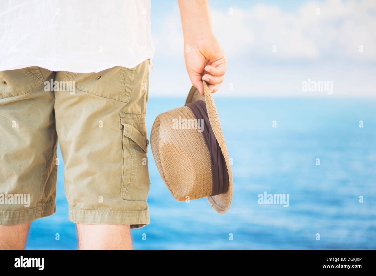 Studio Shot Rear view of man holding straw hat Stock Photo - Alamy